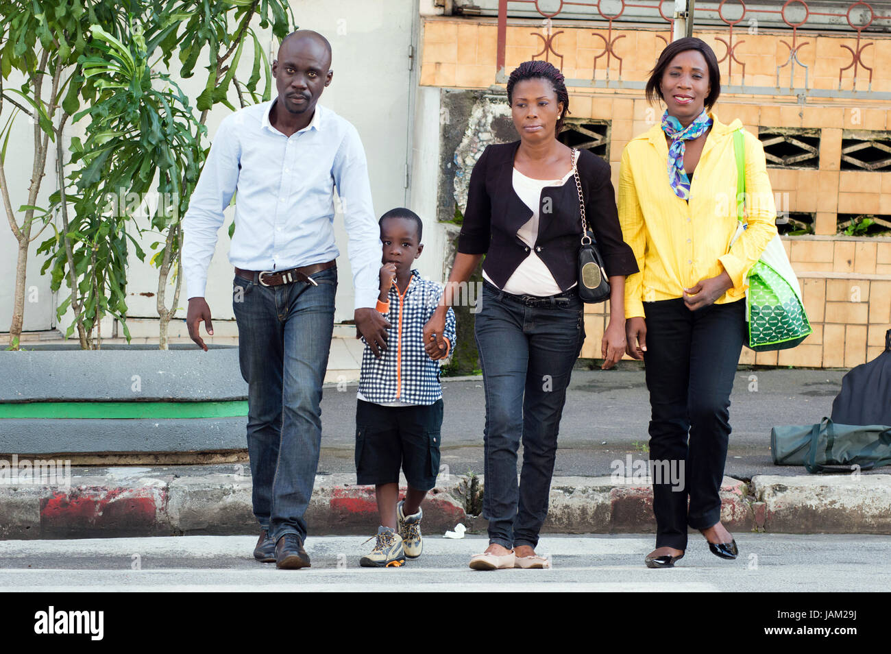 This family aligned across the road by the white stripes of traffic ...