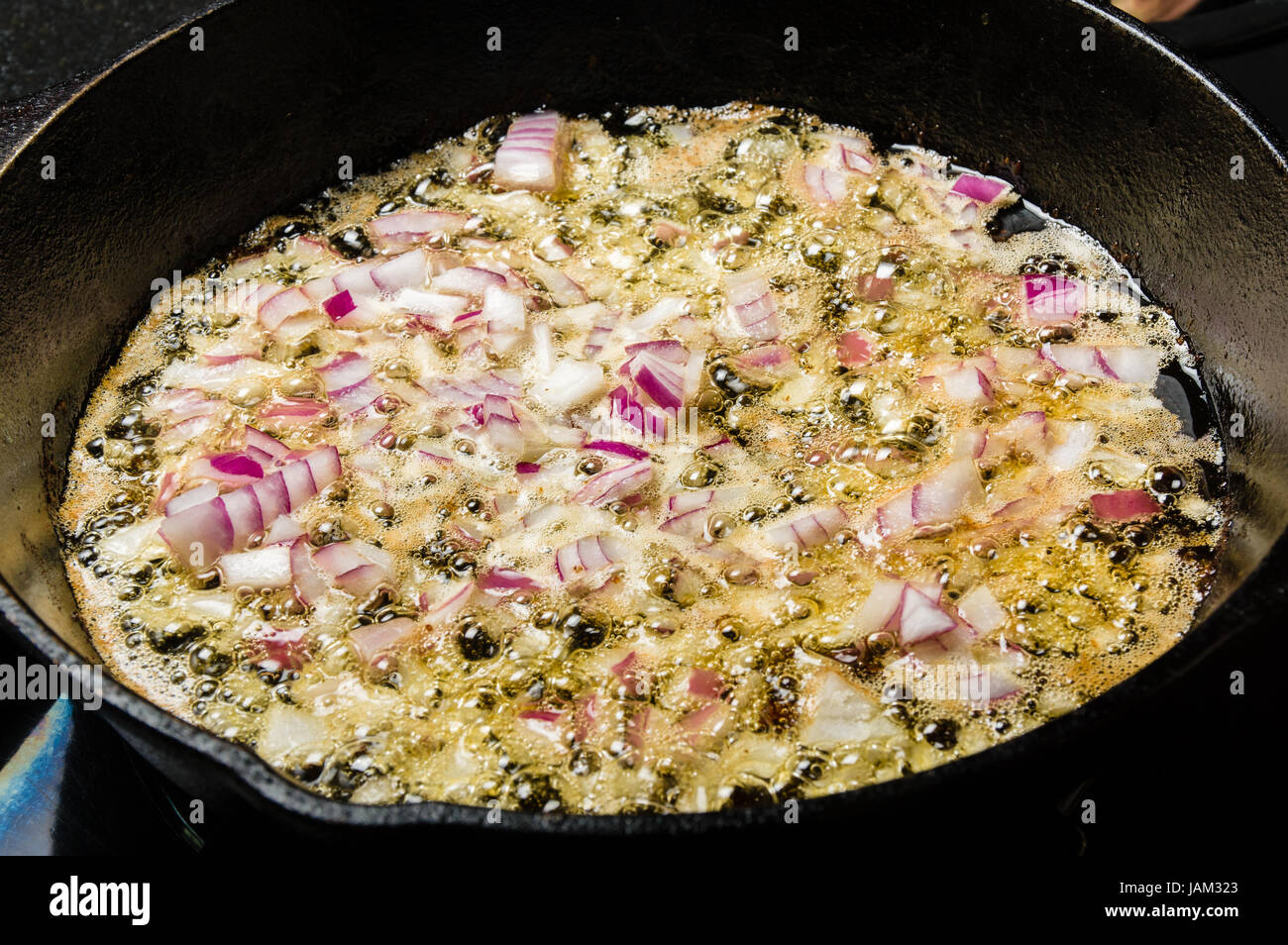Carmelizing cut red onions in a cast iron skillet Stock Photo - Alamy