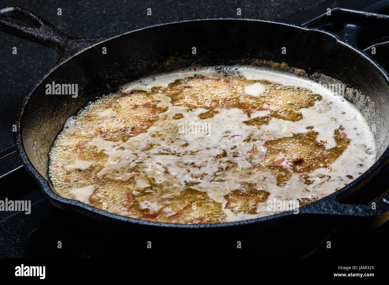Boiling oil or grease on a cast iron skillet Stock Photo - Alamy