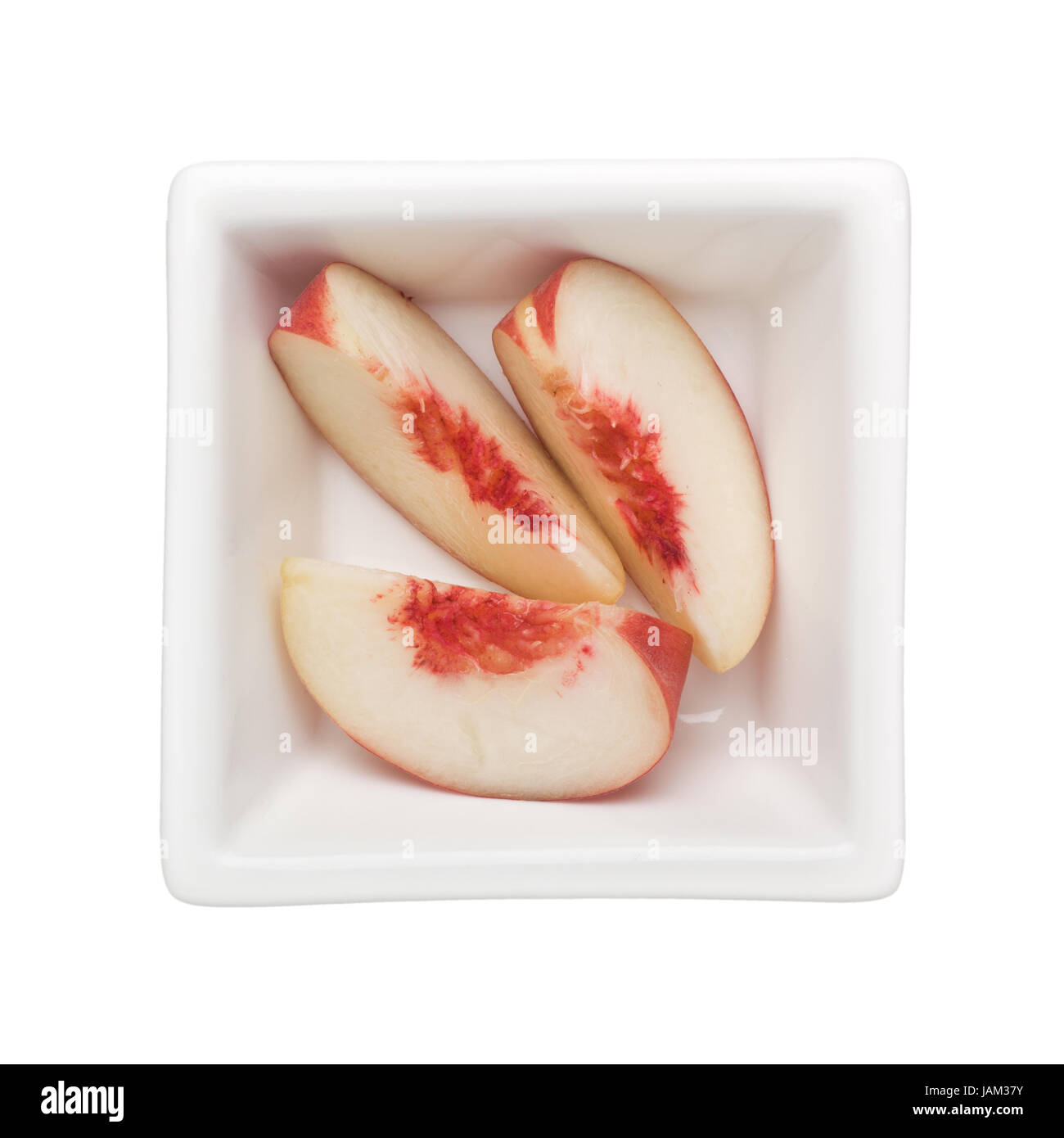 Sliced peach in a square bowl isolated on white background Stock Photo ...