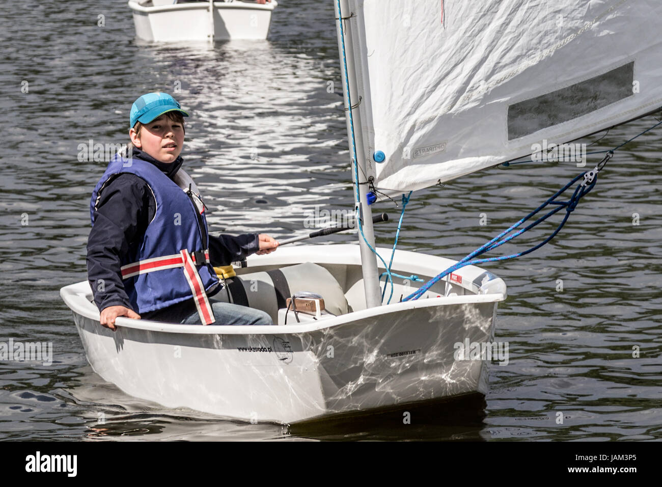Young boy - sailor on Optimist class sailboat, after regatta race Stock ...