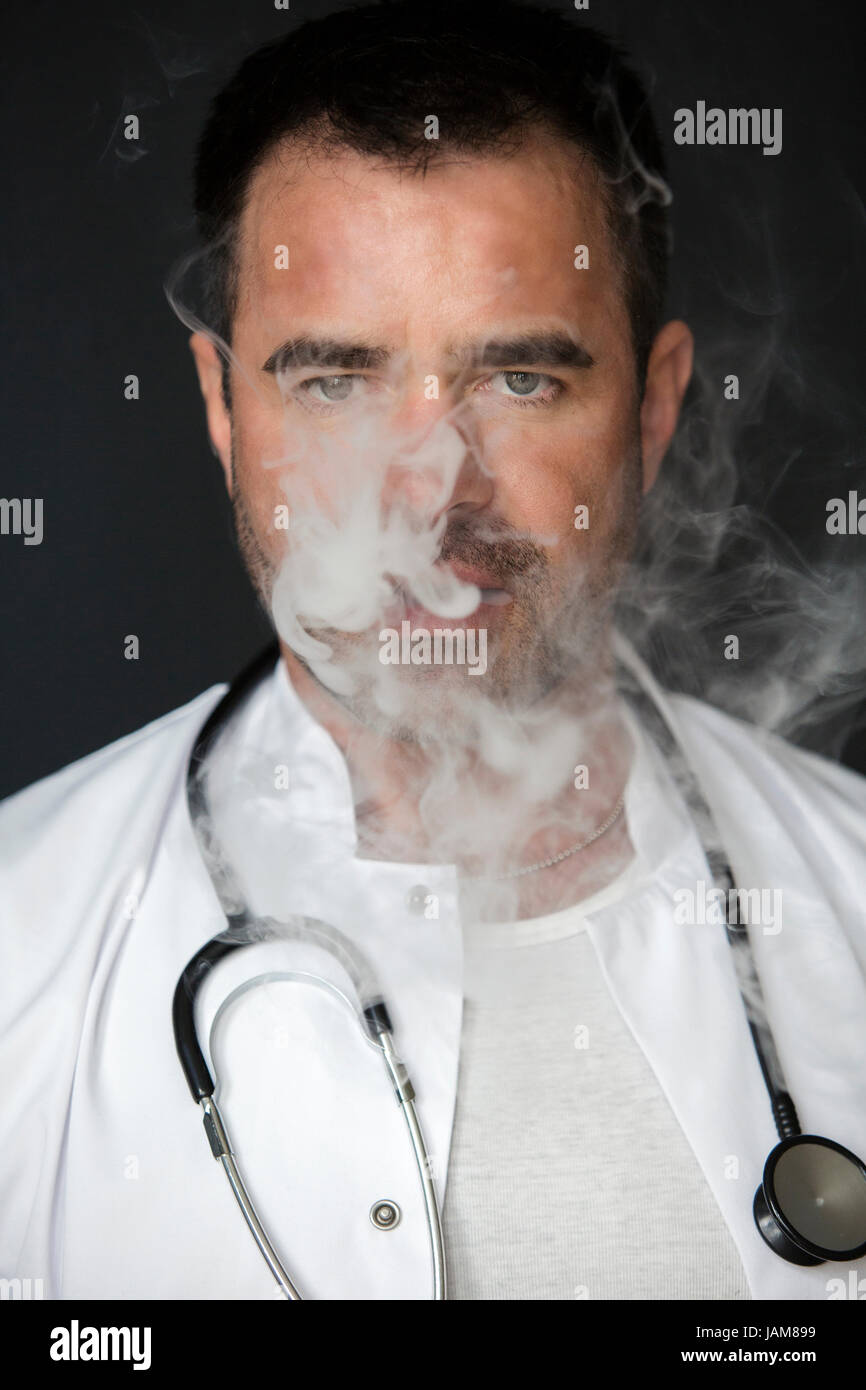portrait of handsome doctor smoking and blowing out smoke Stock Photo ...