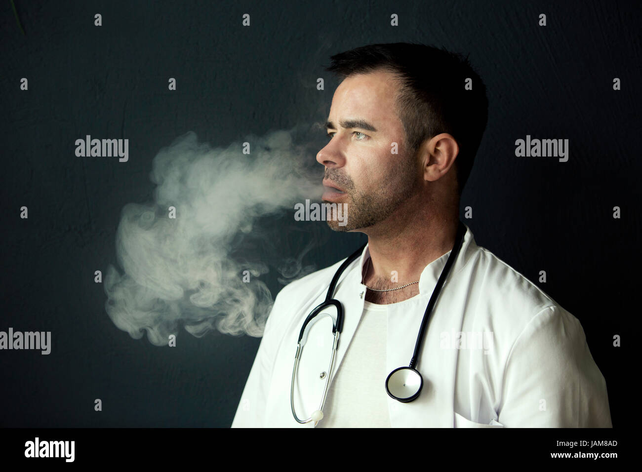 portrait of handsome doctor smoking and blowing out smoke Stock Photo ...