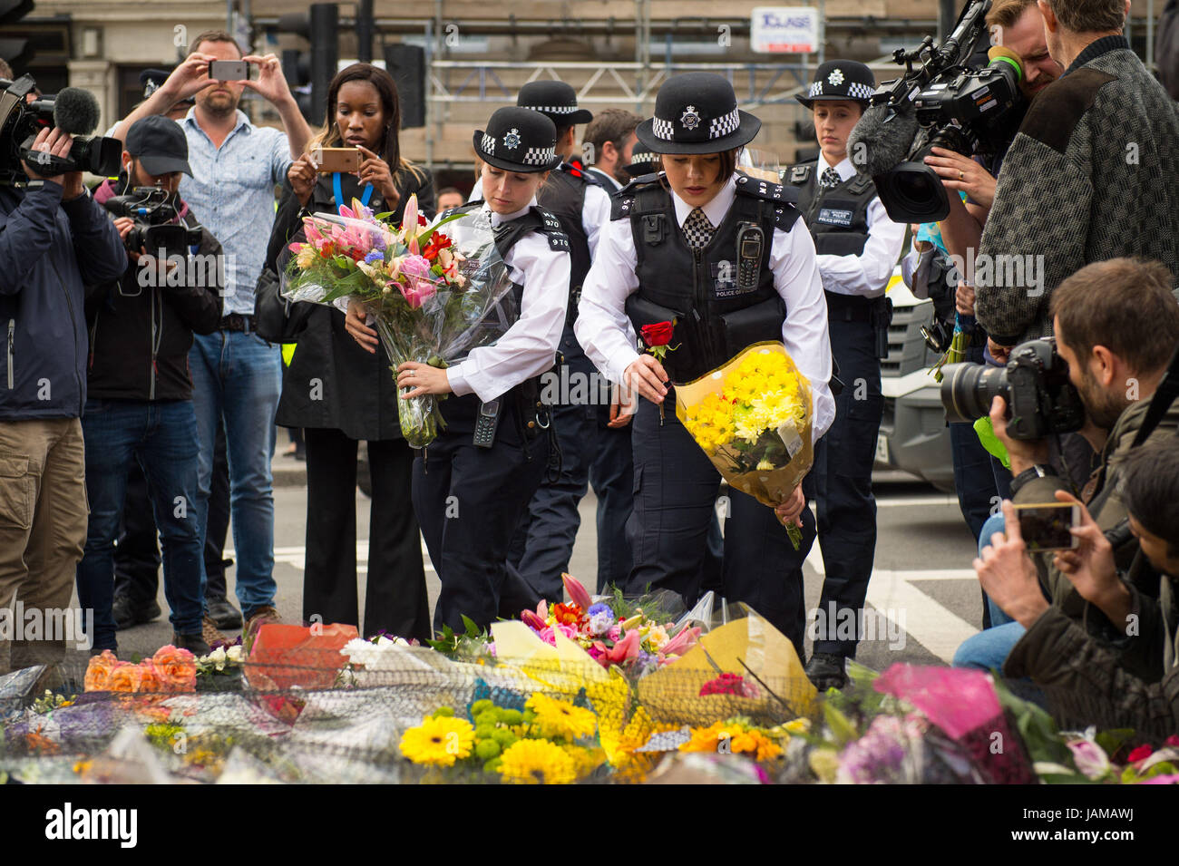 Police officers lay flowers on London Bridge near to the scene of ...
