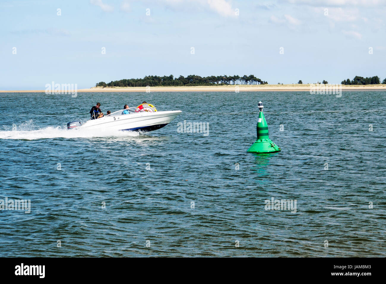 A speedboat passes a marker buoy in the channel into the harbour at ...