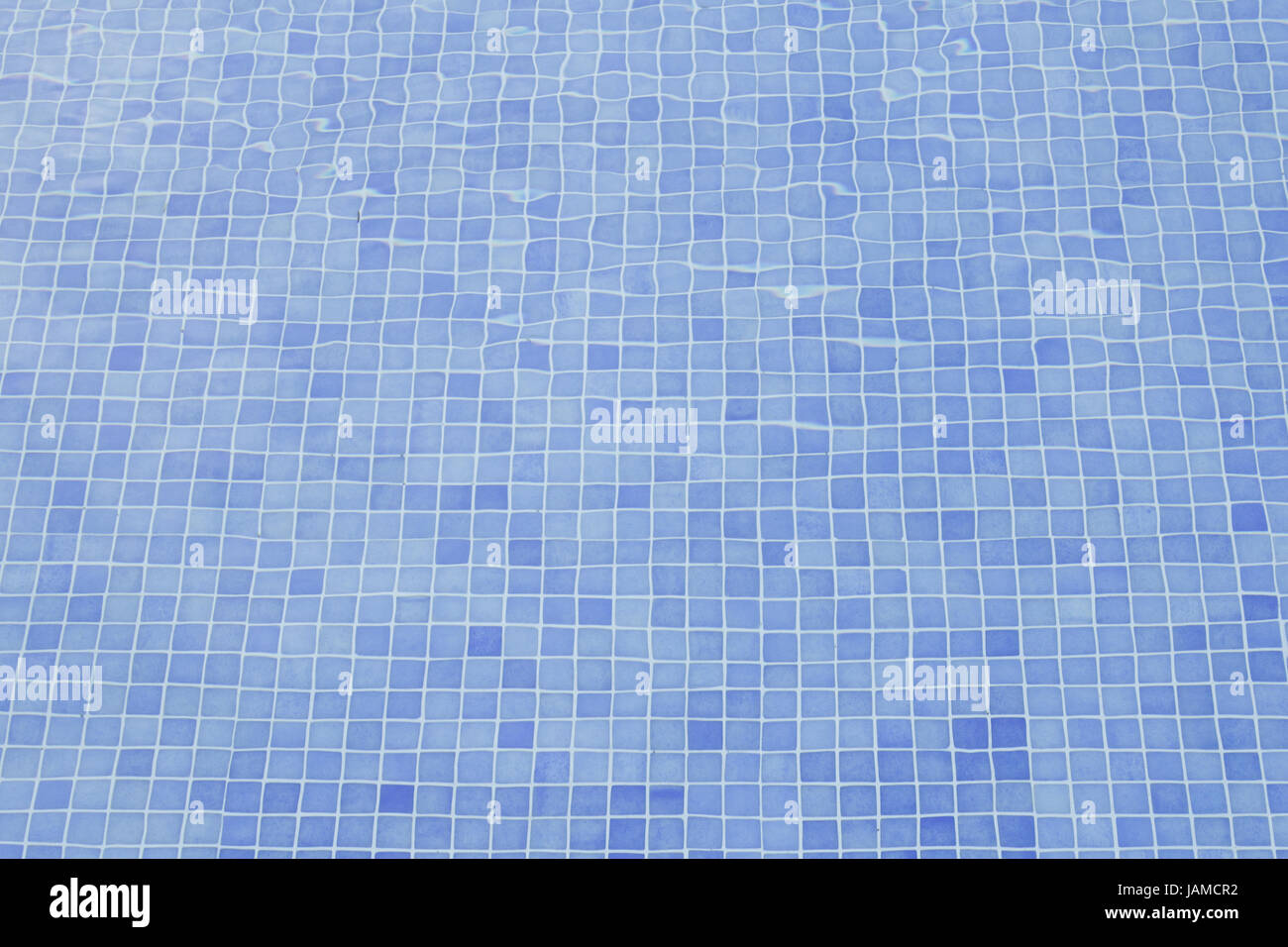 Swimming pool filled with moving water and blue tiles Stock Photo - Alamy
