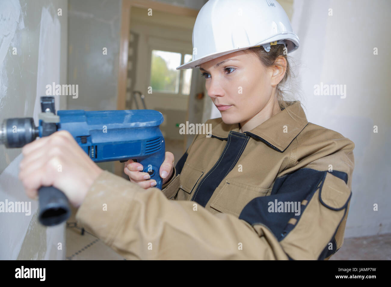 female construction worker demolishing old brick wall with drill Stock ...
