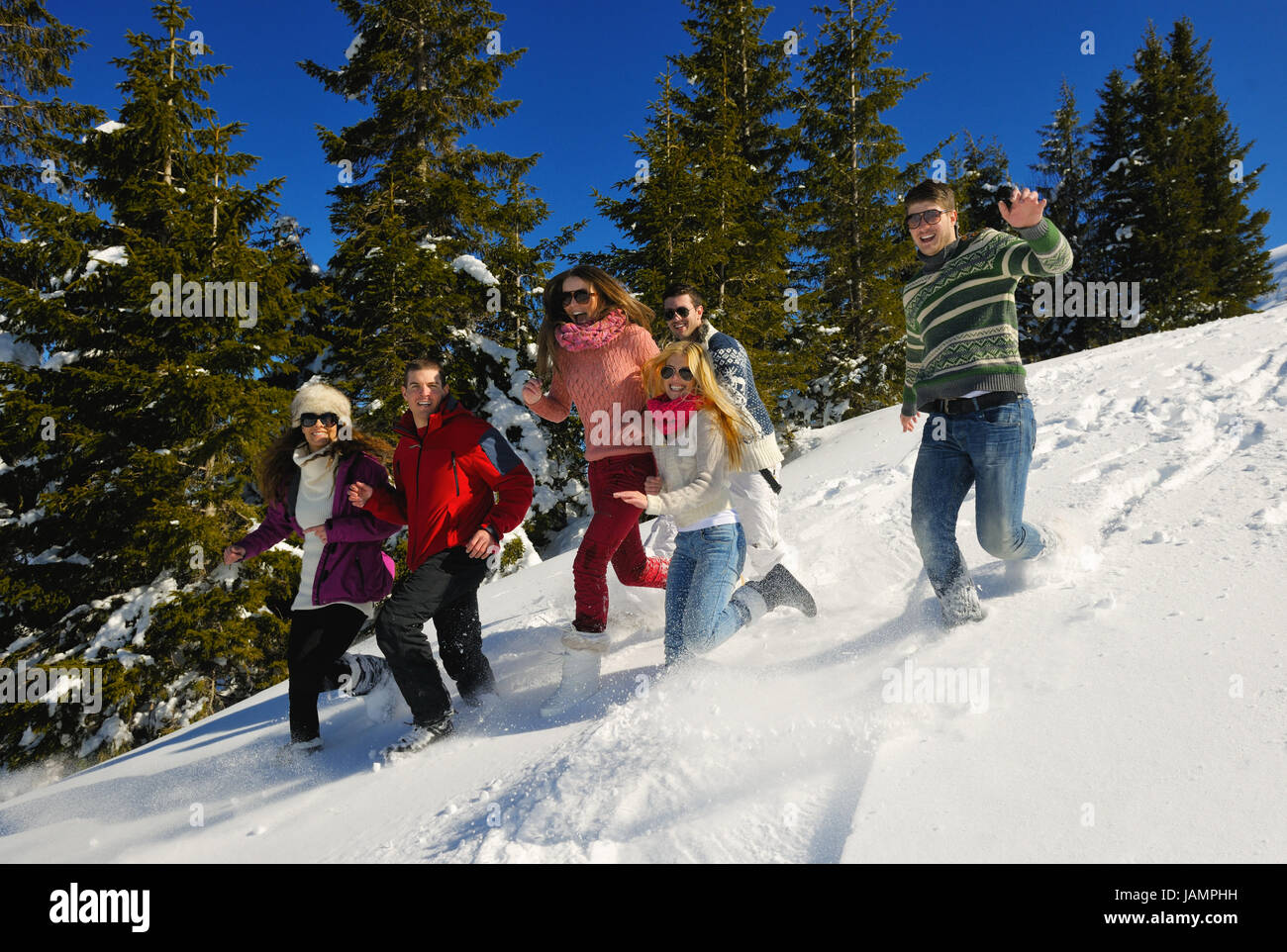 happy friends have fun at winter on fresh snow, healthy young people ...