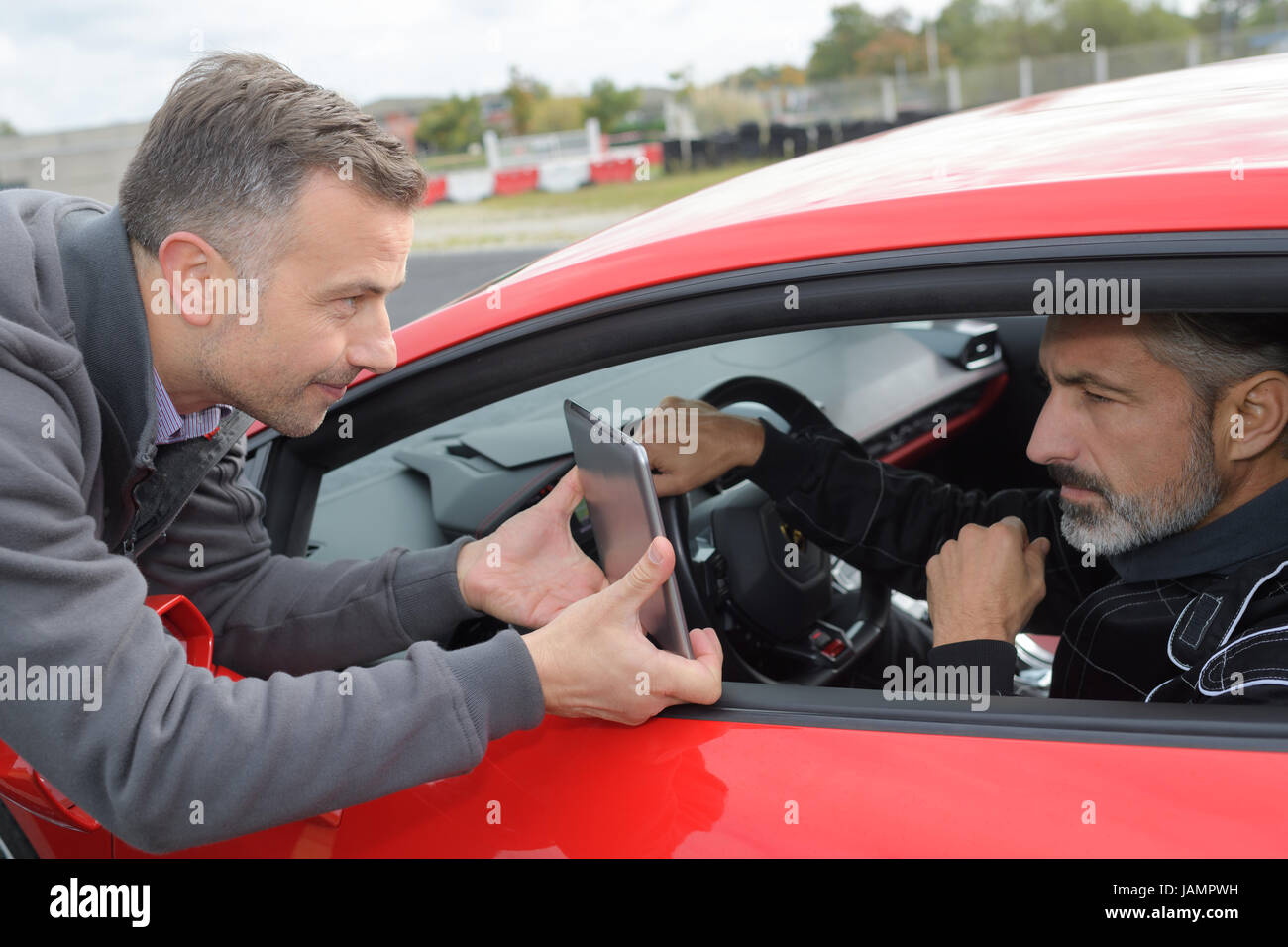 sports driver taking tips from coach Stock Photo - Alamy