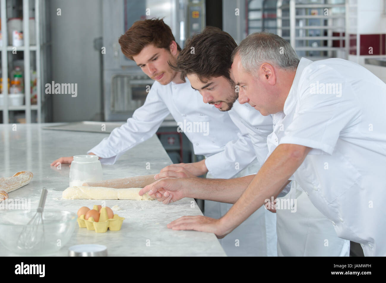 instructor in bakery teaching apprentice how to form a dough Stock ...