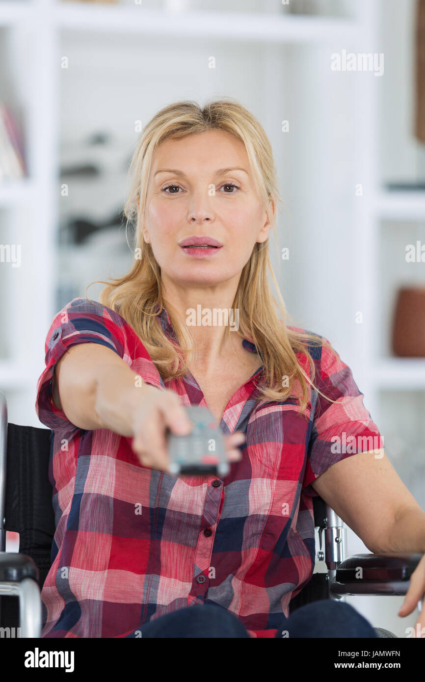 handicapped woman using remote control while watching television Stock ...