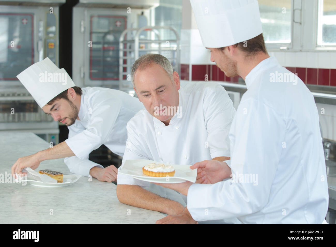 male chefs and assistants working at kitchen Stock Photo - Alamy
