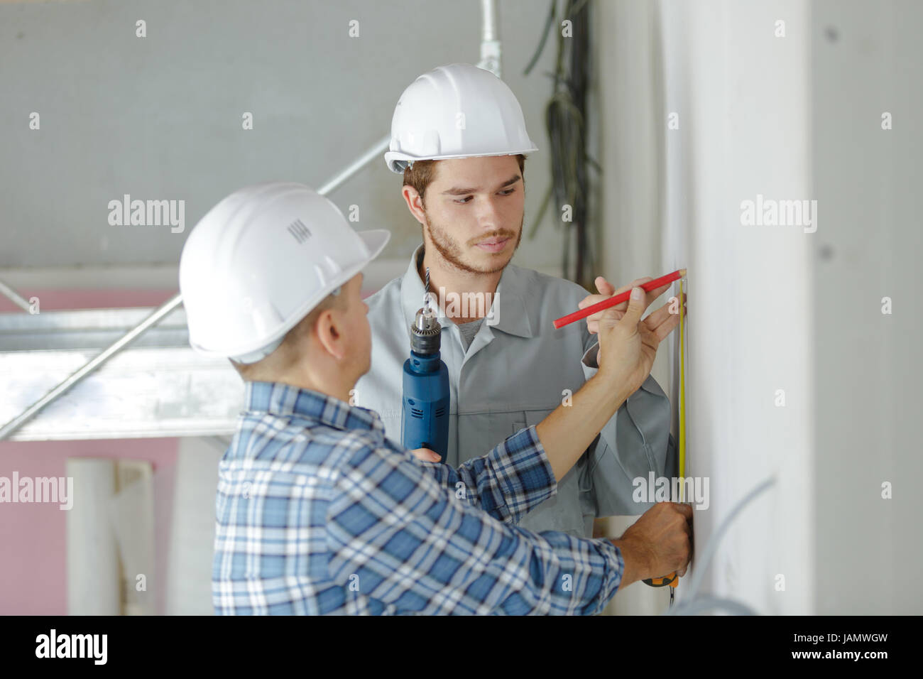 specialist and assistant working with wall in new building Stock Photo ...
