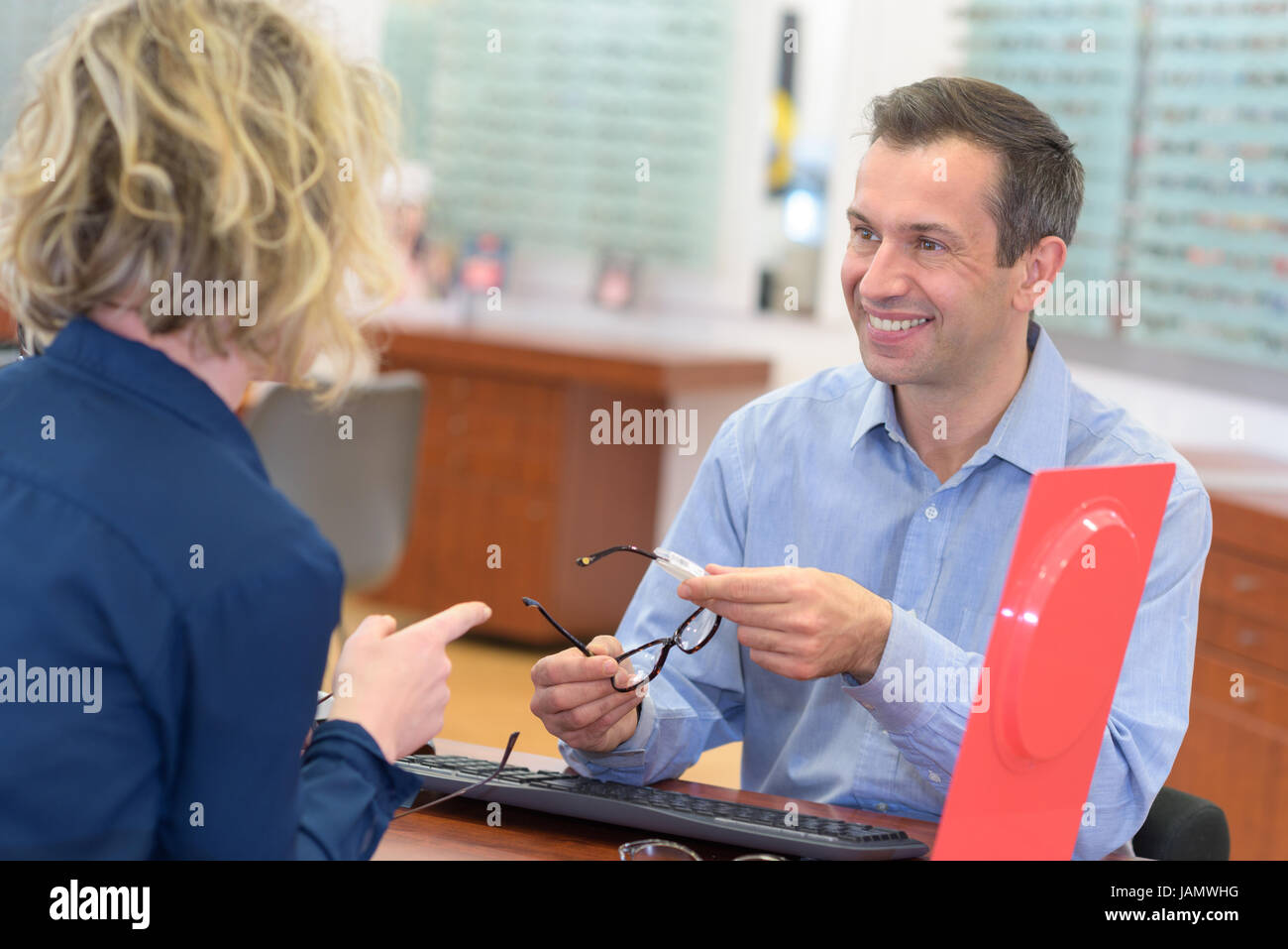 attractive optician working with customer in his glasses shop Stock ...