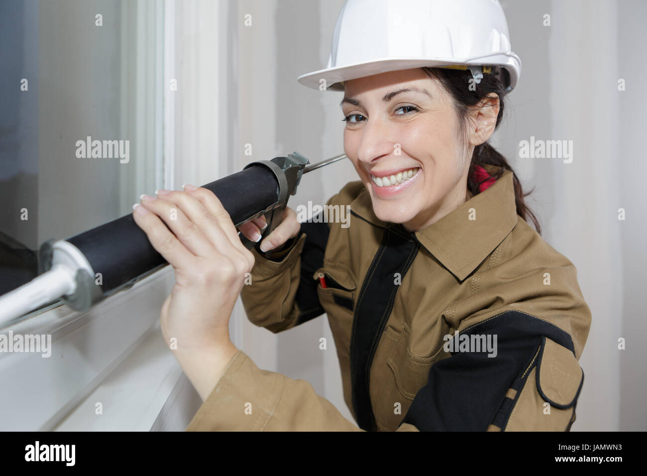 happy female contractor using silicone Stock Photo - Alamy