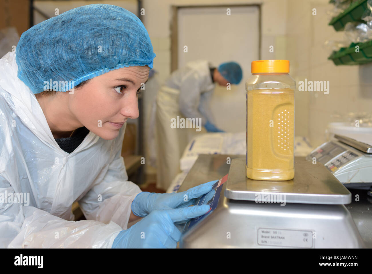 Factory worker weighing sample Stock Photo - Alamy
