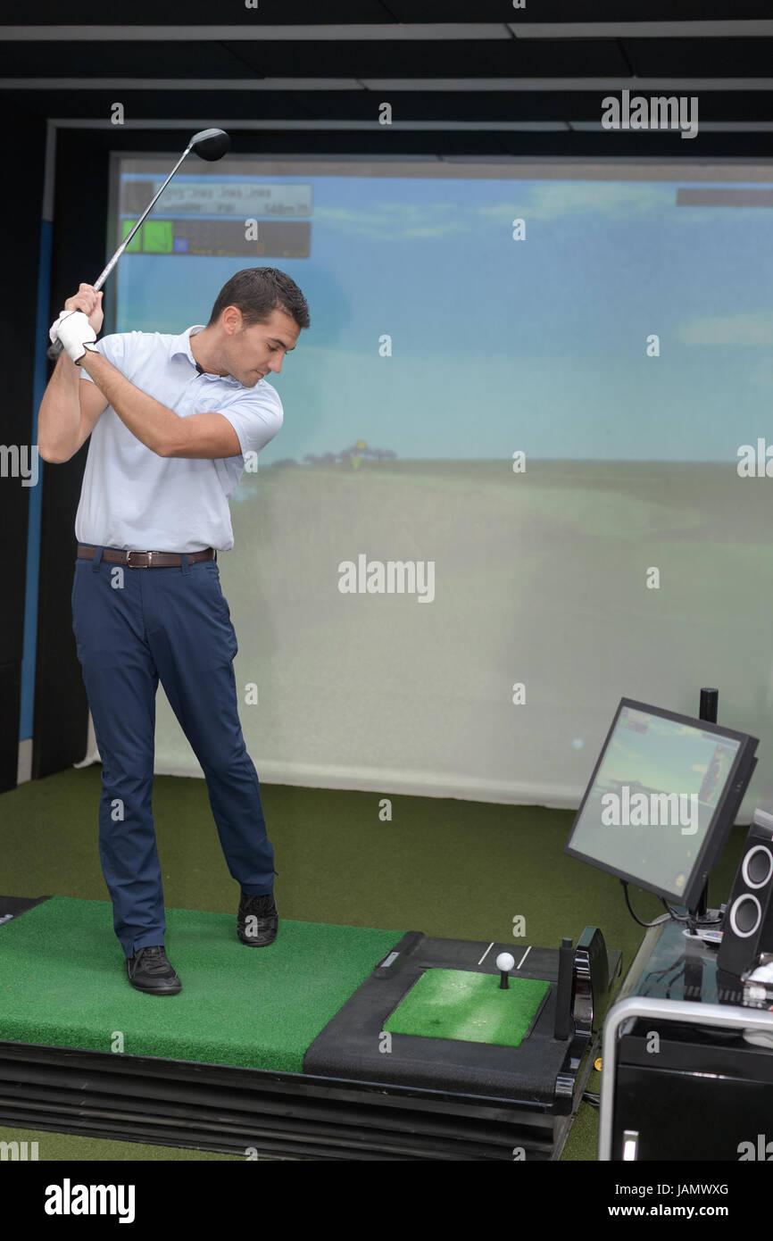 golfer hitting long shot with driver indoors Stock Photo - Alamy