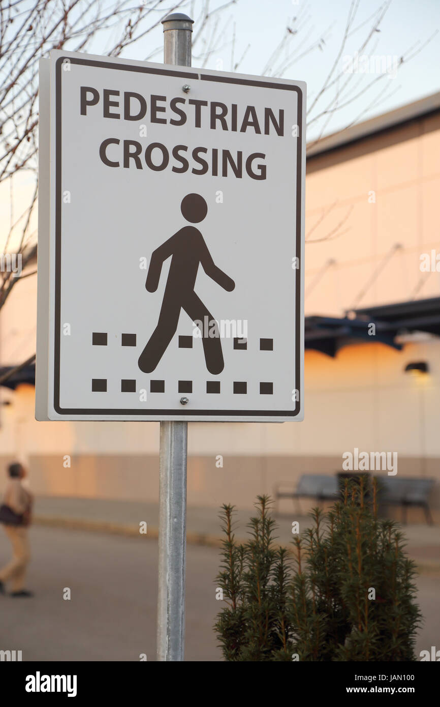 Pedestrian crossing road sign with building background Stock Photo - Alamy