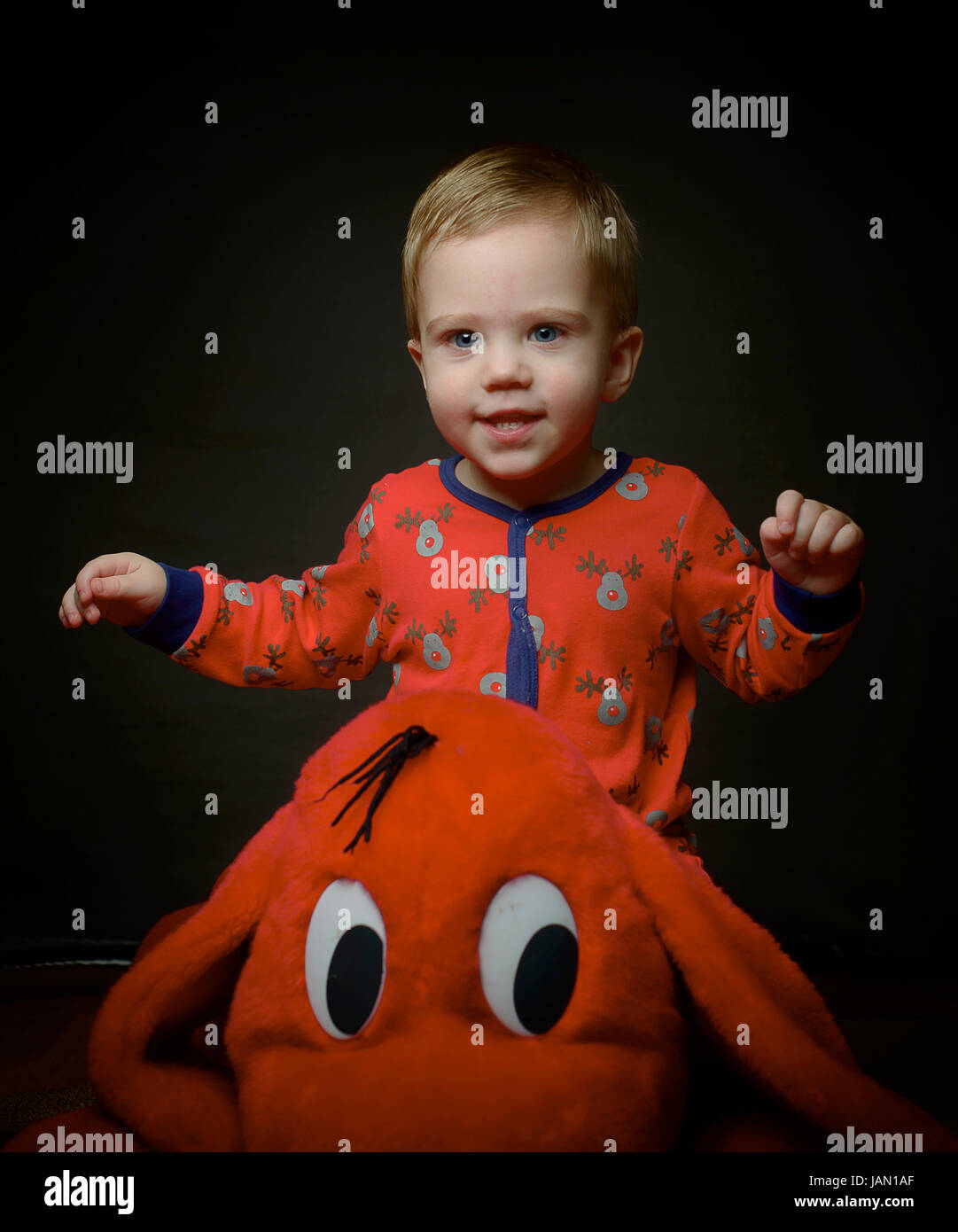 cute blonde little boy in red with his toy Stock Photo - Alamy