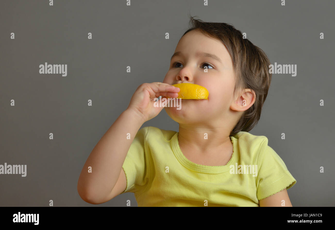 little girl eating a lemon Stock Photo - Alamy
