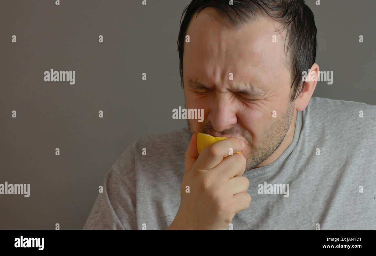 man eating lemon and making silly faces Stock Photo - Alamy
