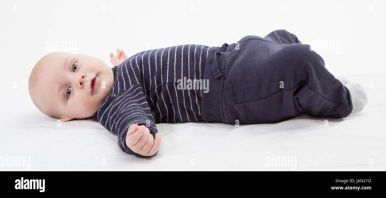 smiling toddler in blue clothing laying down. vertical image Stock ...