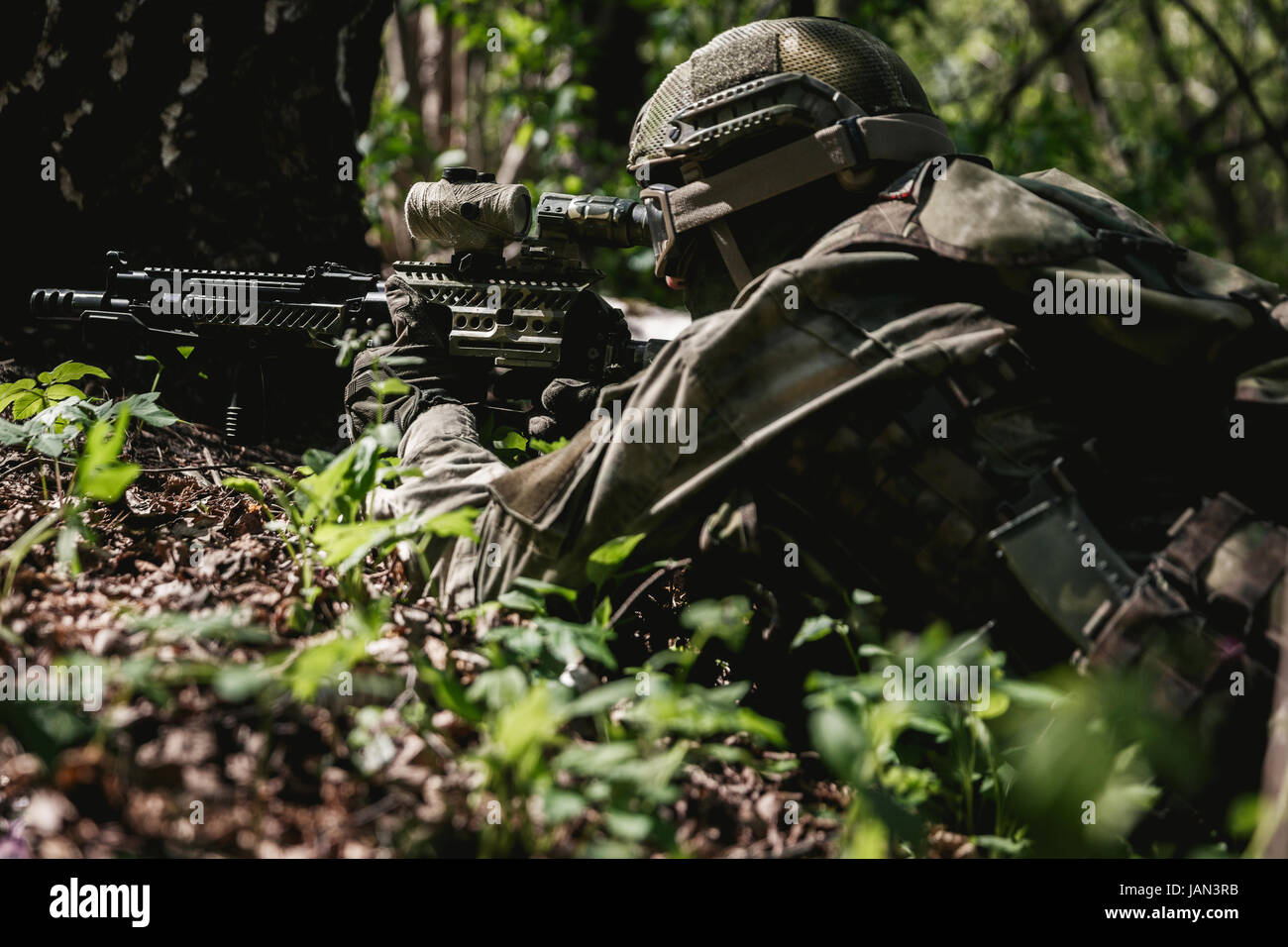 Soldier with submachine gun lies in ambush at forest Stock Photo - Alamy