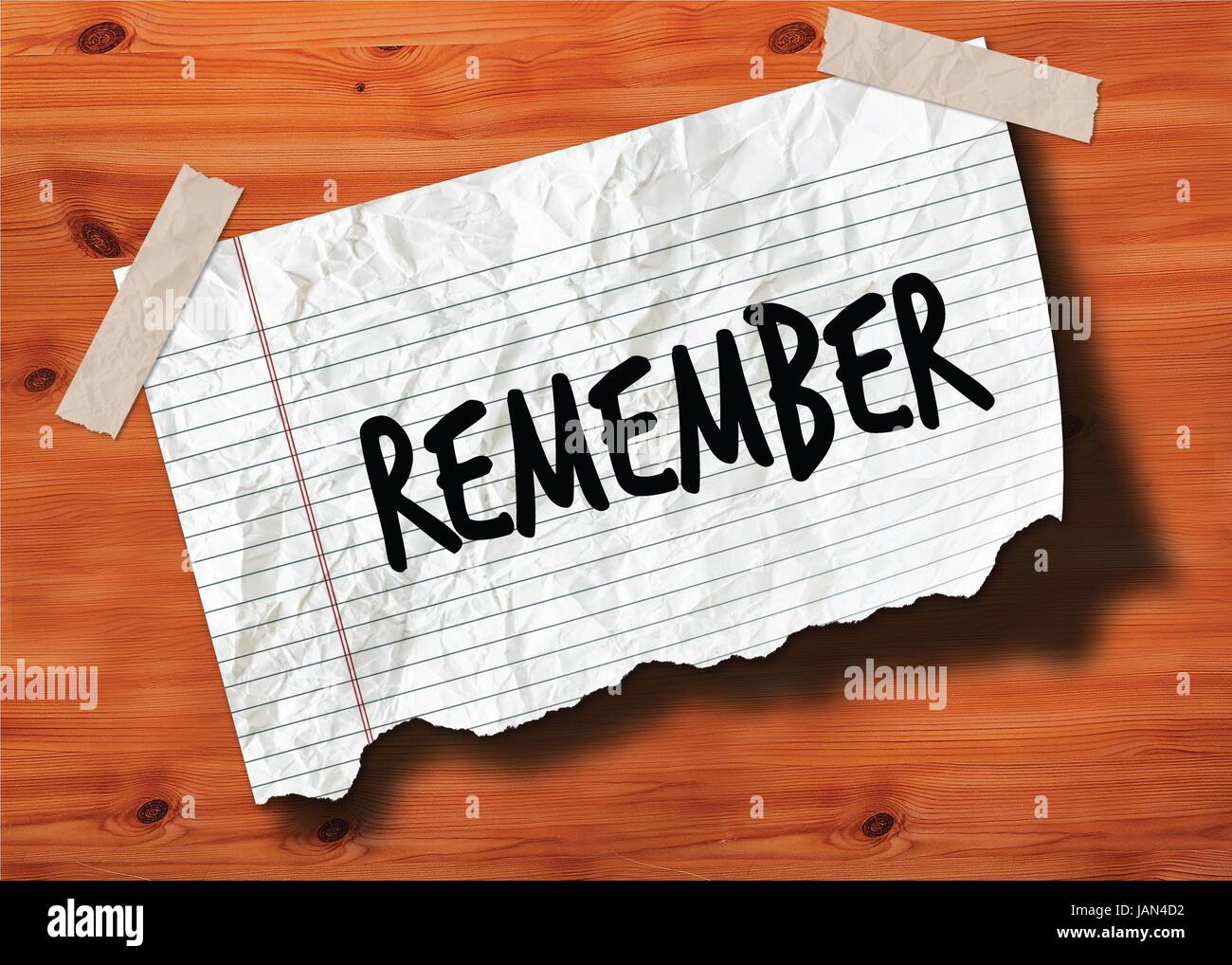 REMEMBER handwritten on torn notebook page crumpled paper on wood ...