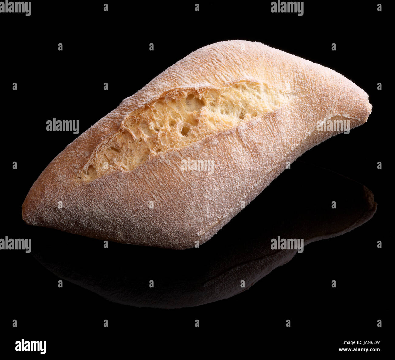 frozen german bread roll in black reflective back Stock Photo - Alamy