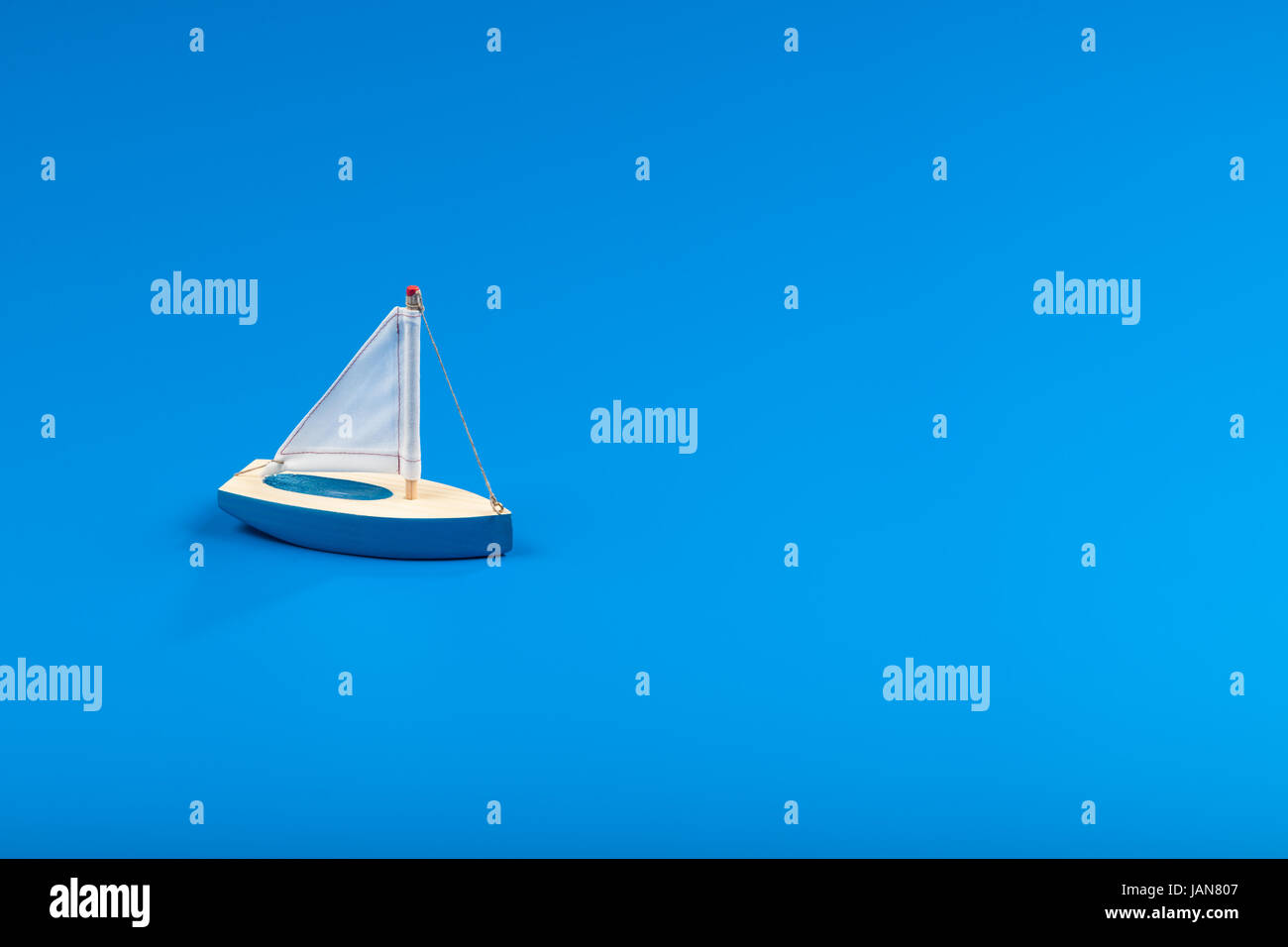 Little blue toy boat exploring the blue ocean Stock Photo - Alamy