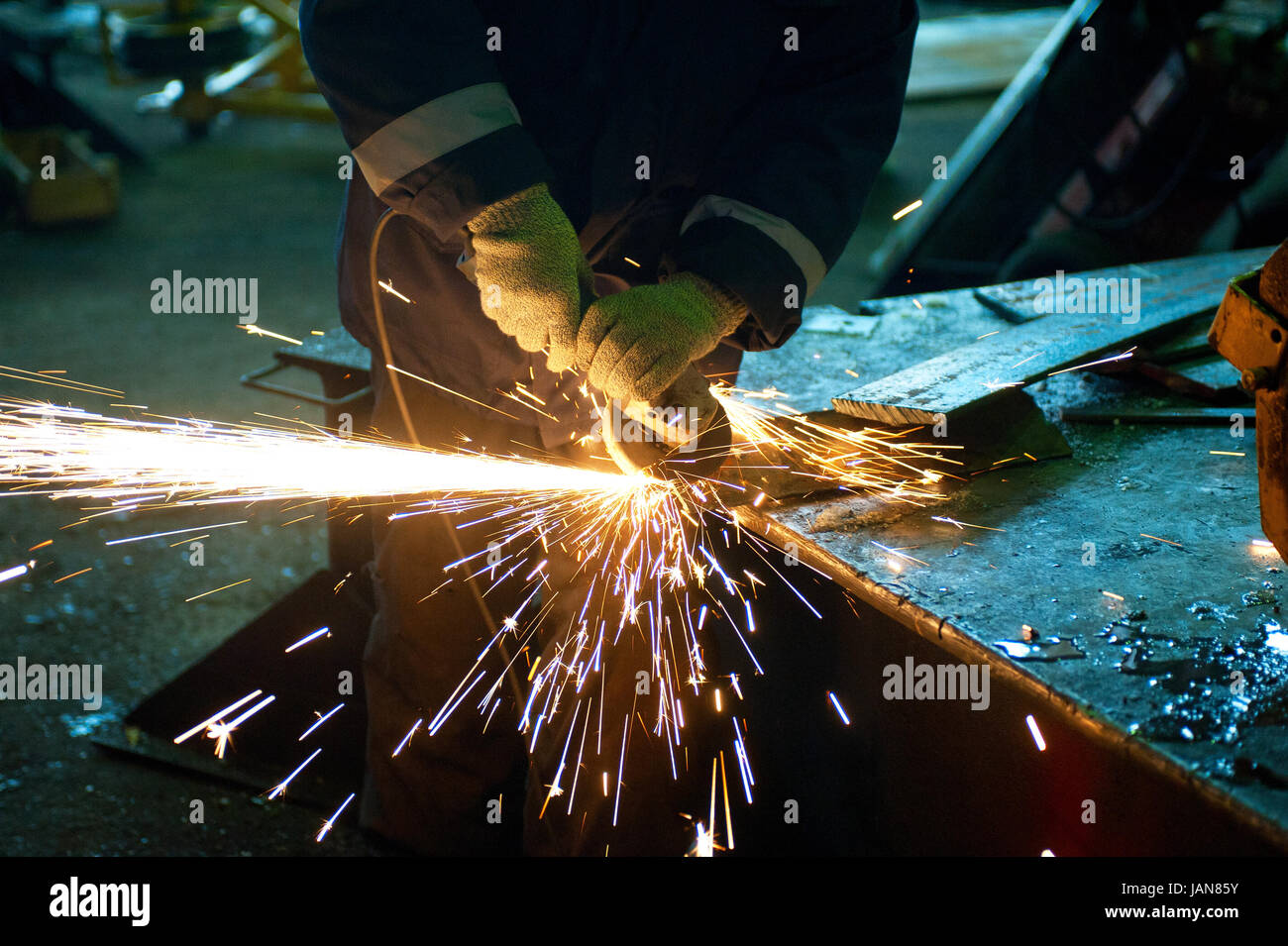 worker welding metal with sparks at factory Stock Photo - Alamy