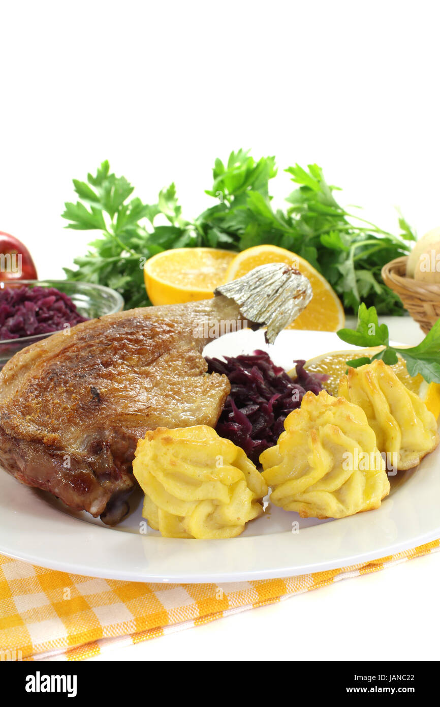heiße Entenkeule mit Herzoginkartoffeln und Rotkohl vor hellem ...