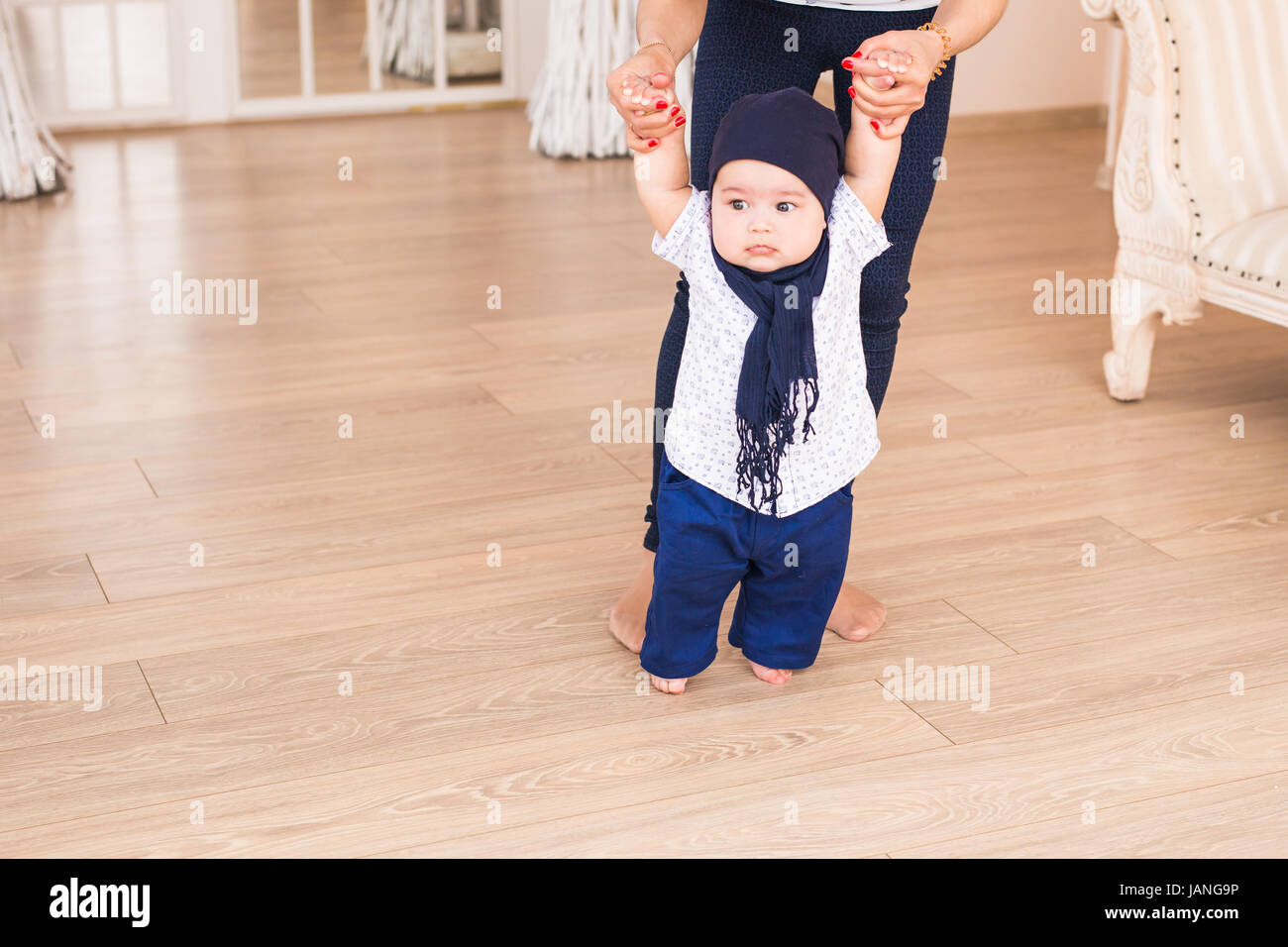 baby taking first steps with mother help Stock Photo - Alamy
