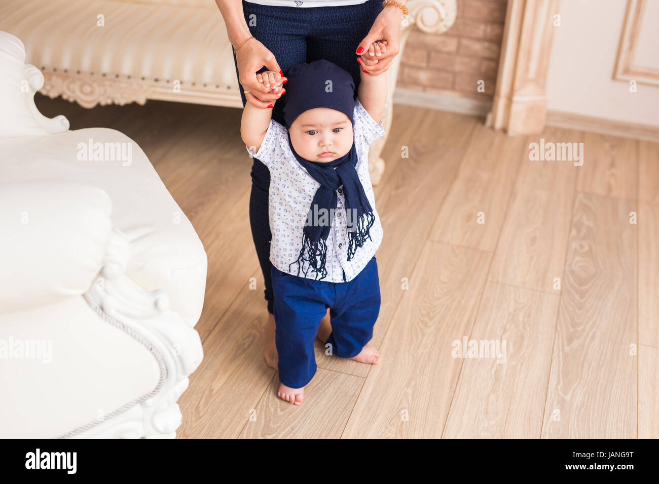 baby taking first steps with mother help Stock Photo - Alamy