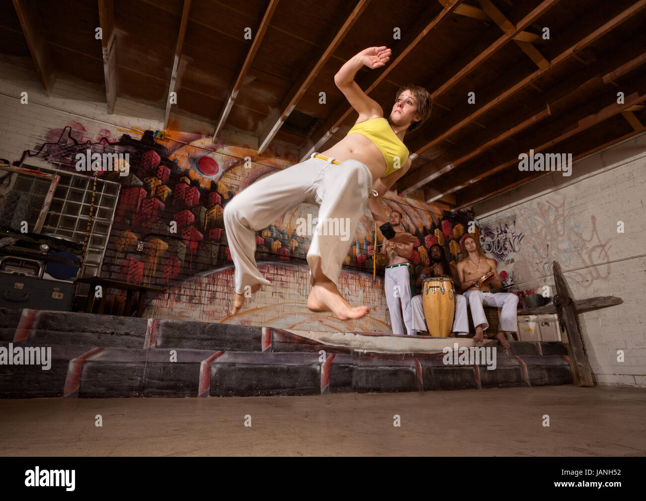 Flexible woman performing a capoeira jumping kick Stock Photo - Alamy