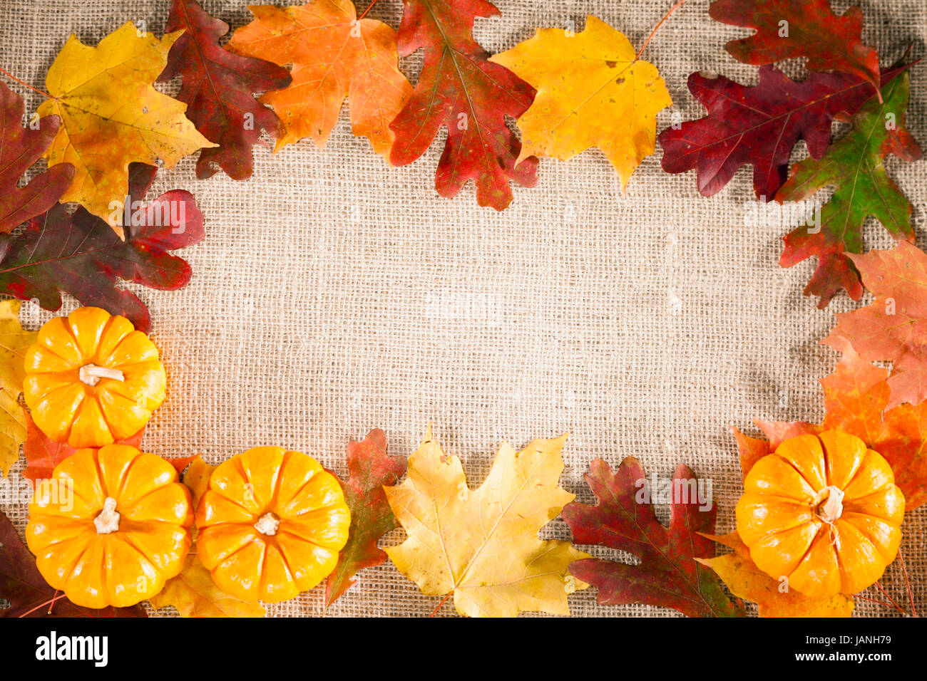 Fall-themed background of burlap, dry leaves and pumpkins Stock Photo ...