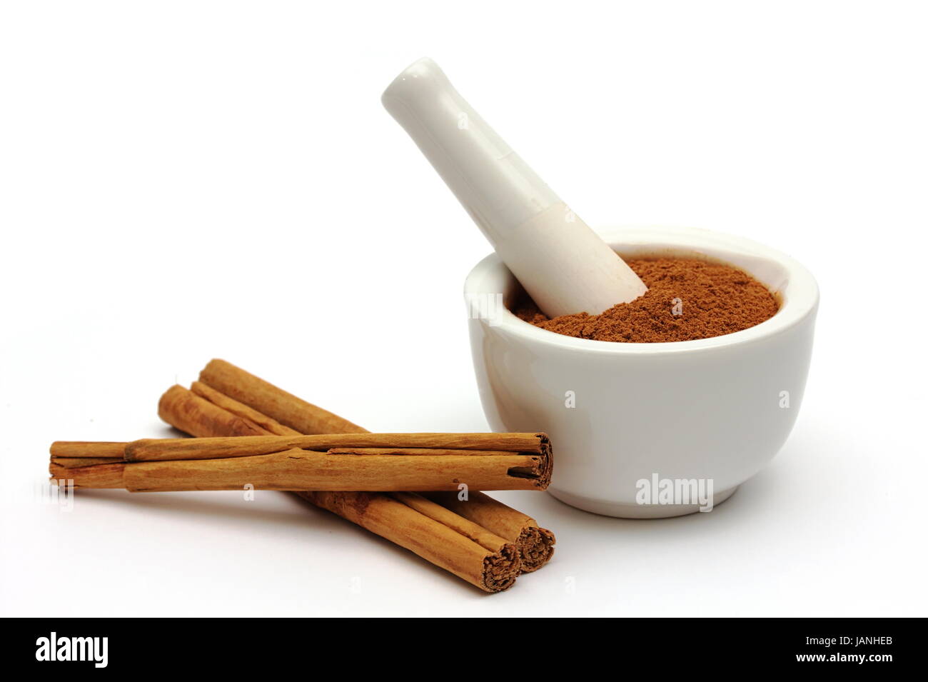 Grounded cinnamon in a bowl with cinnamon sticks isolated on white ...