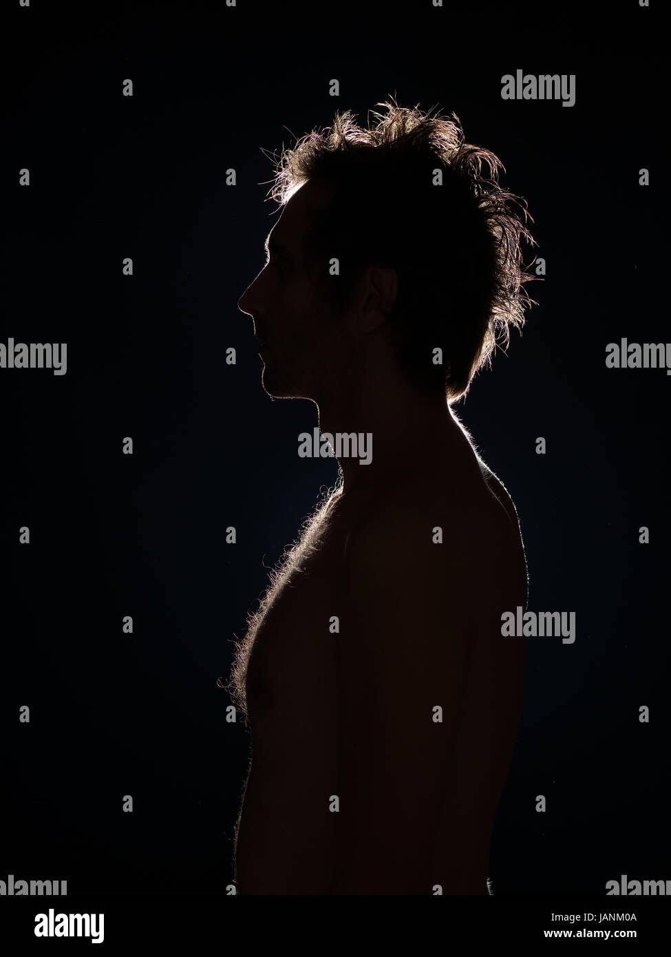side view of man with back ligthing on black background Stock Photo - Alamy