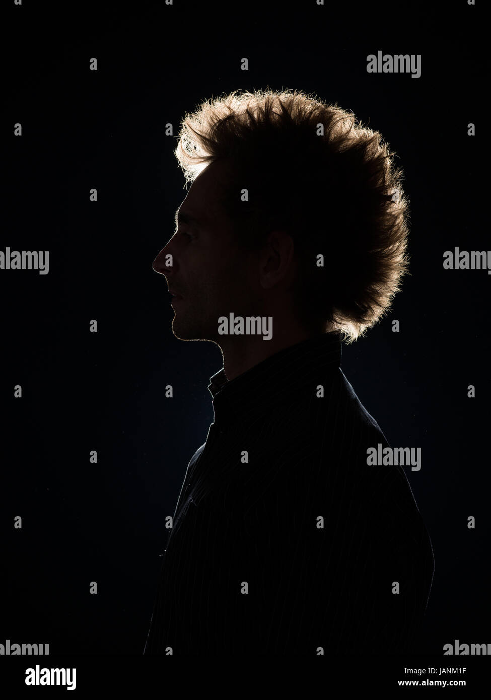 side view of man with back lighting on black background Stock Photo - Alamy