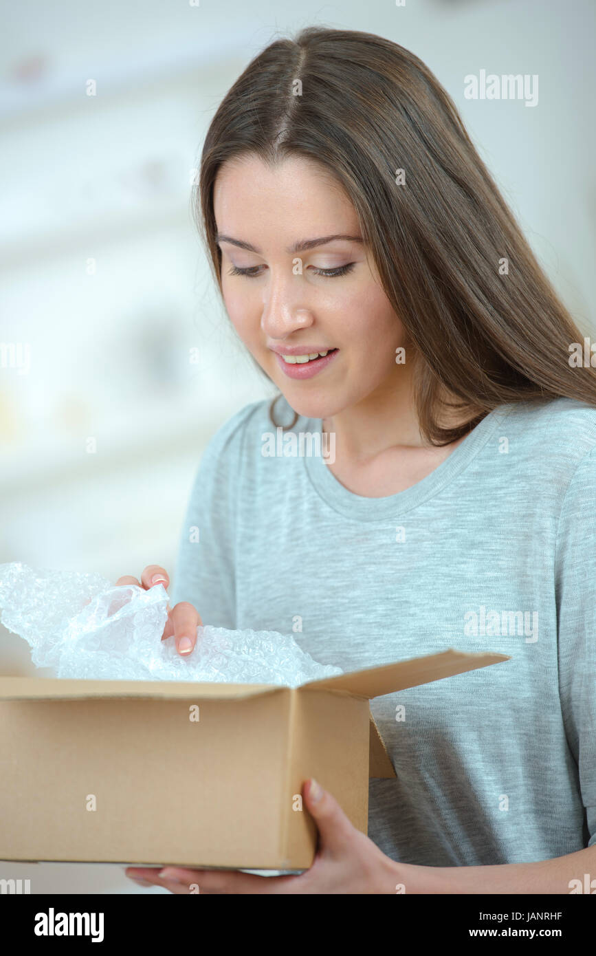 pleasant woman opening a box Stock Photo - Alamy