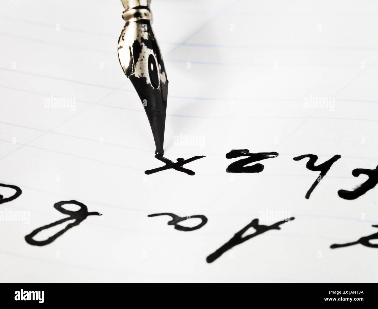 writing of set of letters by black ink nib on white sheet of notebook ...