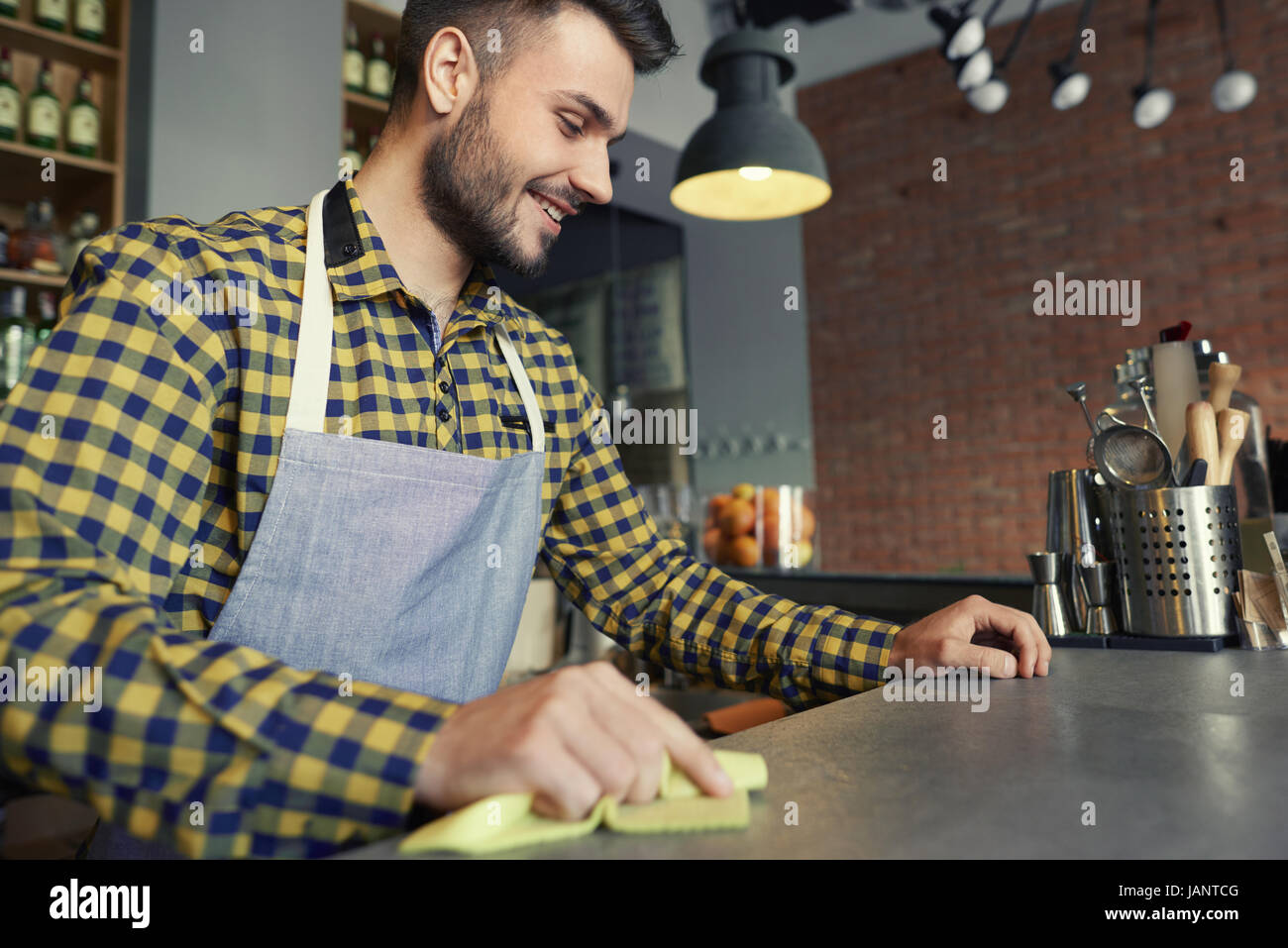 Waiter cleaning bar counter before work Stock Photo - Alamy
