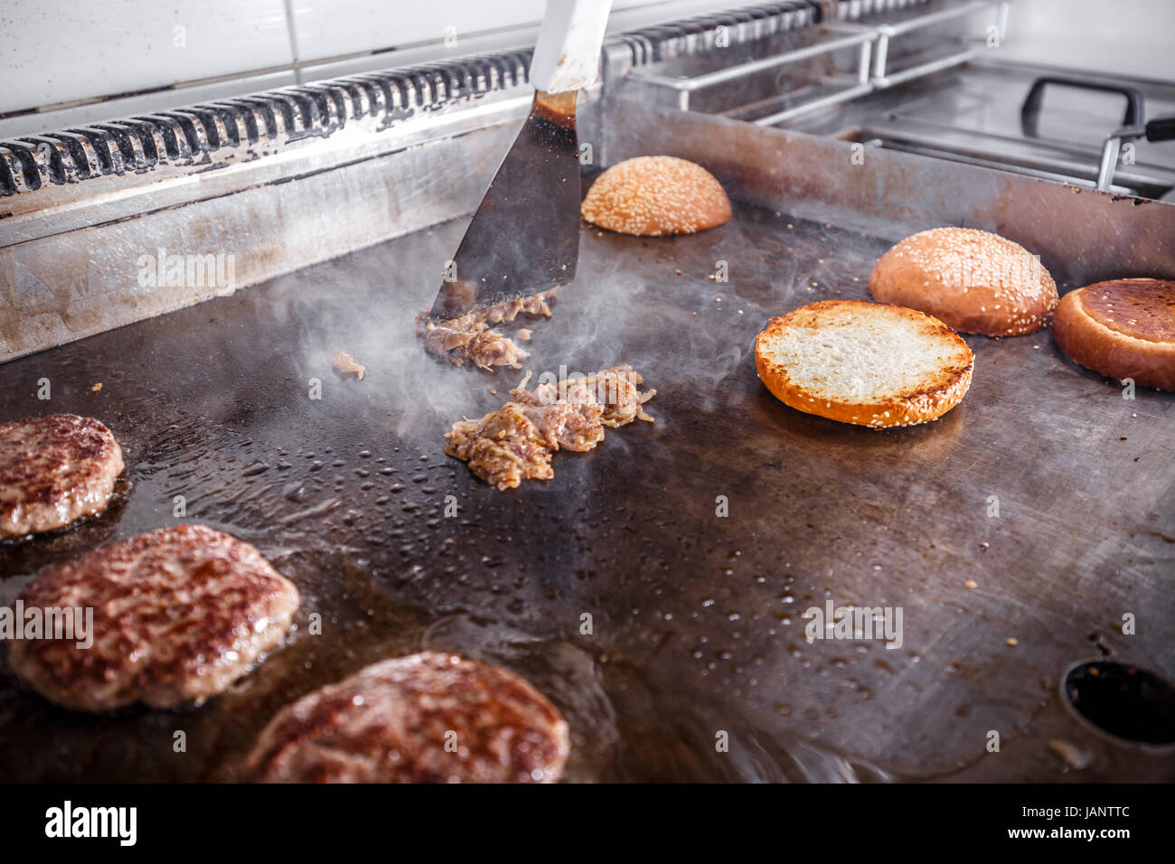 The cook prepare beef for cheese burger in fast food restaurant Stock ...