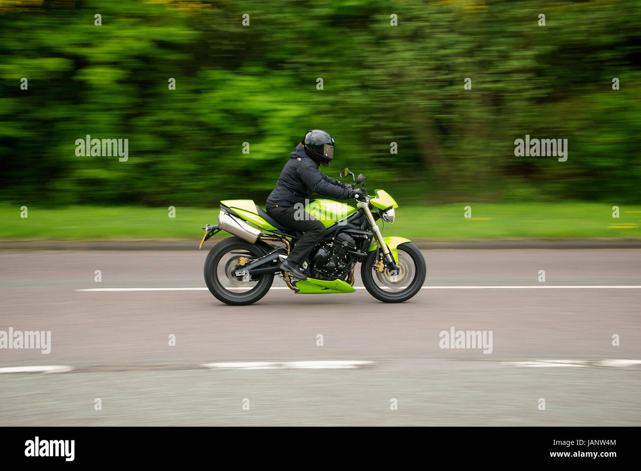 Motorcycle rider on the road at speed on a Triumph Street Triple ...