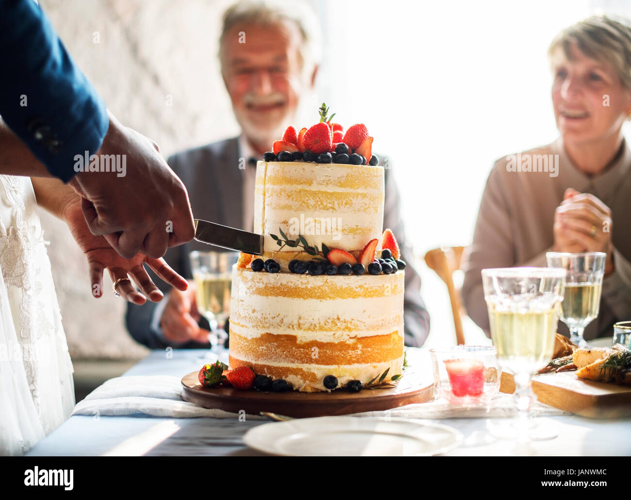 Couple Hands Cutting Wedding Cake Stock Photo - Alamy