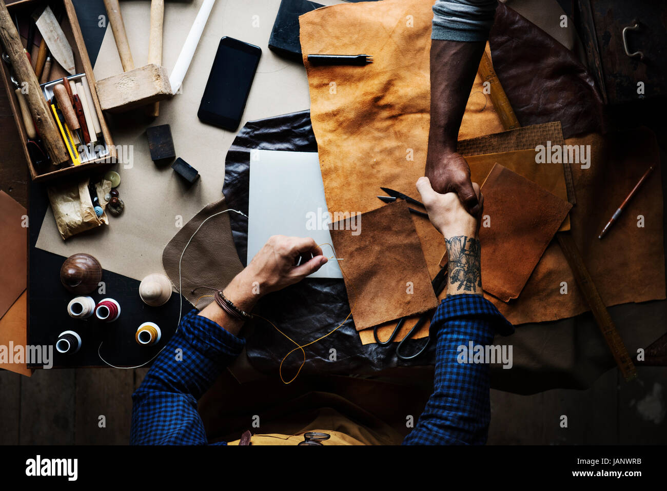 Aerial of learther craftsmen shaking hands together Stock Photo - Alamy