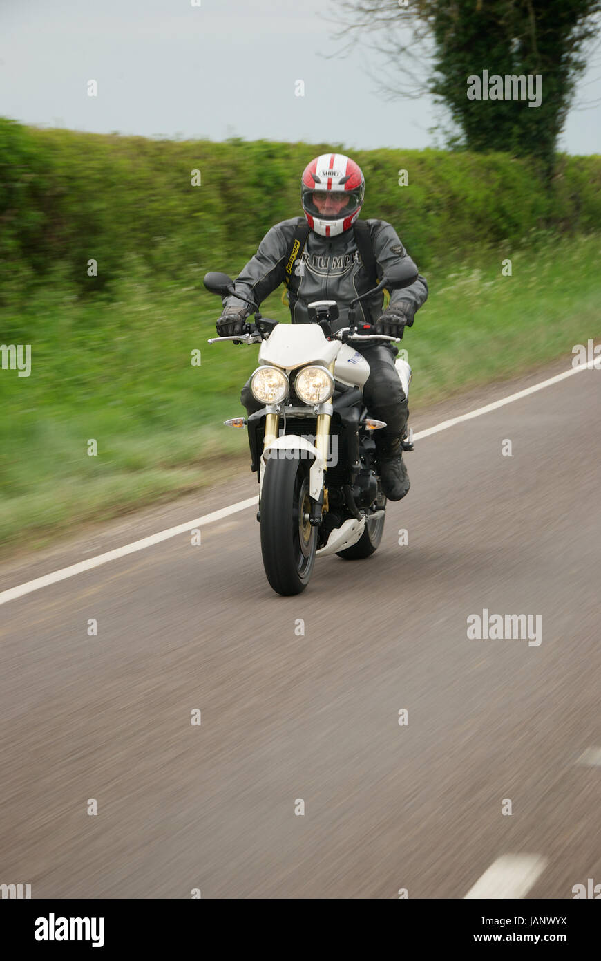 Motorcycle rider on the road at speed on a Triumph Street Triple ...