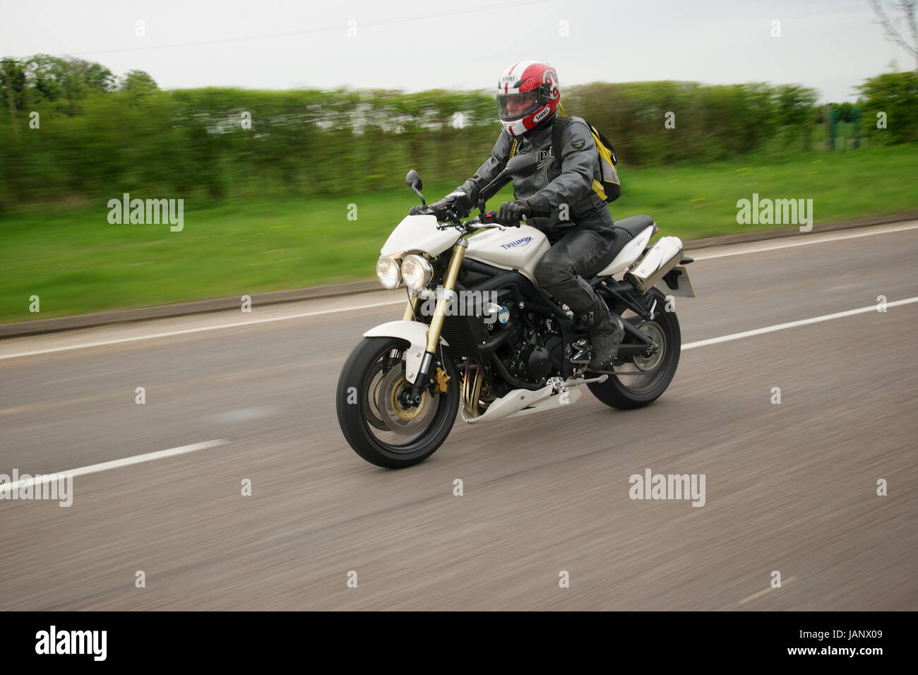Motorcycle rider on the road at speed on a Triumph Street Triple ...