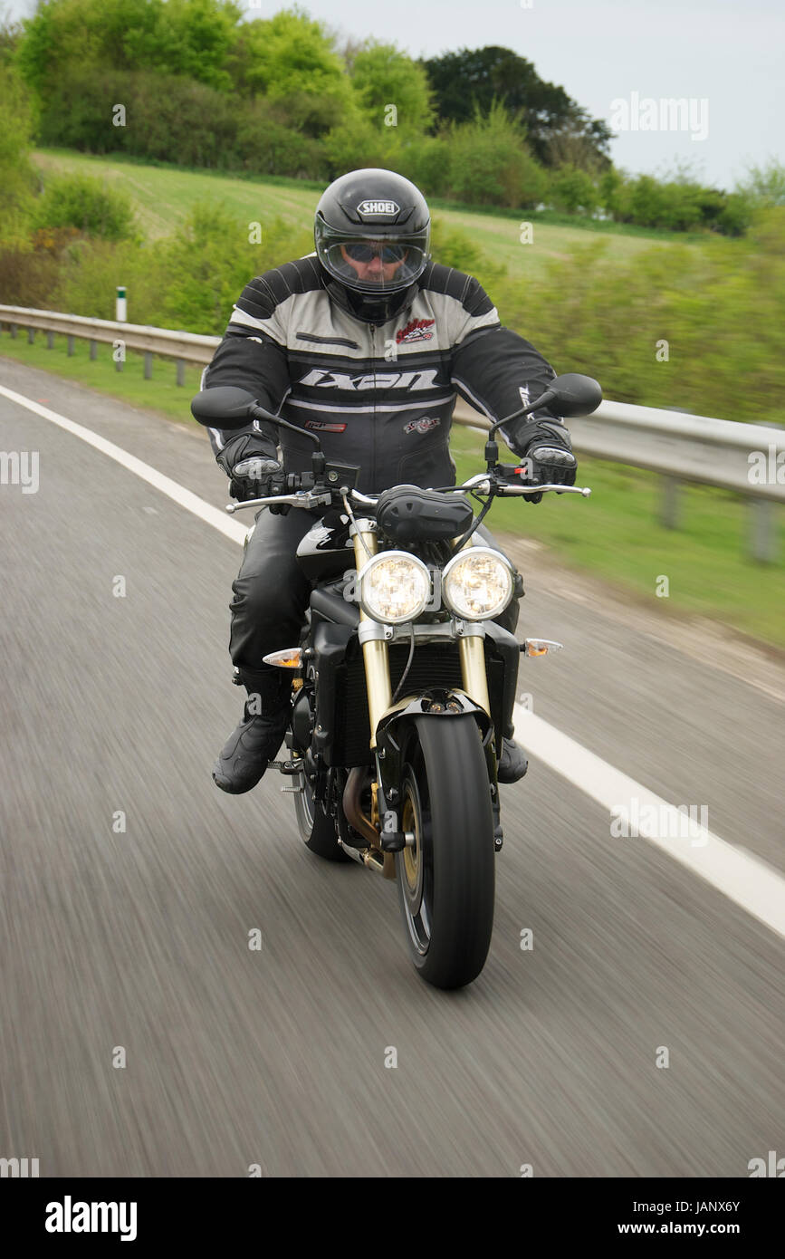 Motorcycle rider on the road at speed on a Triumph Street Triple ...