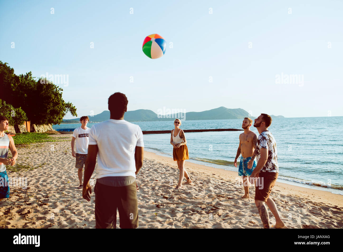 Group of diverse friends playing beach ball together Stock Photo - Alamy